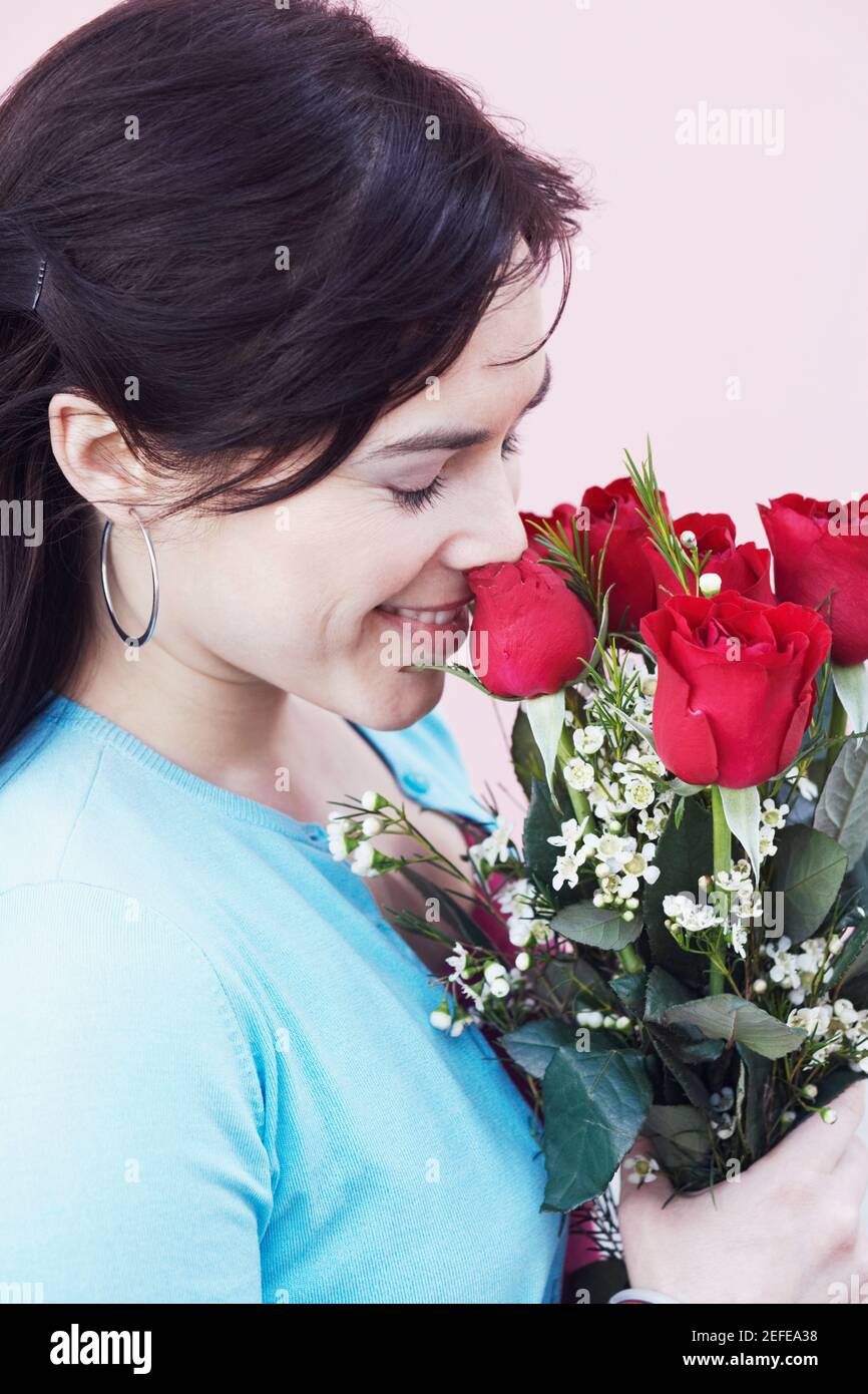 Woman with red hair smelling a red rose hi-res stock photography and ...