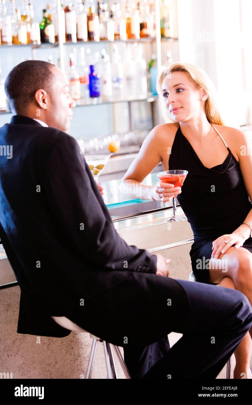 Young couple sitting at a bar counter Stock Photo - Alamy