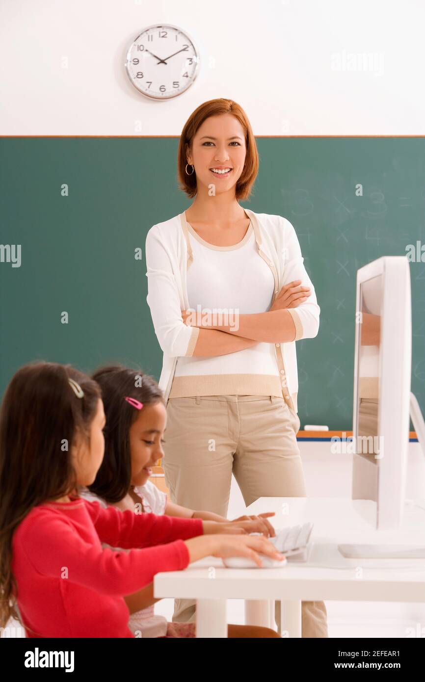 Two girls with their teacher in a classroom Stock Photo - Alamy