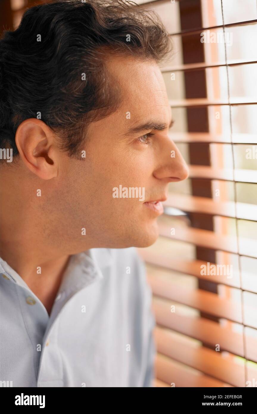 Close-up of a young man looking out of a window Stock Photo - Alamy
