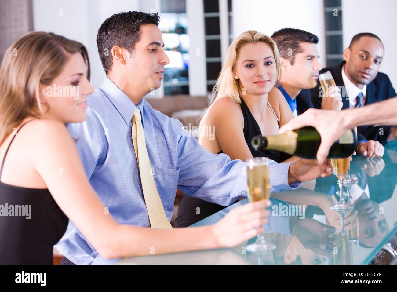 Five people sitting at a bar counter Stock Photo - Alamy