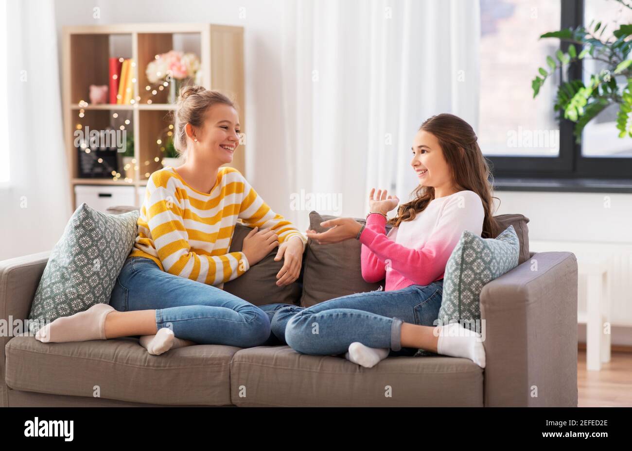 happy teenage girls talking on sofa at home Stock Photo - Alamy