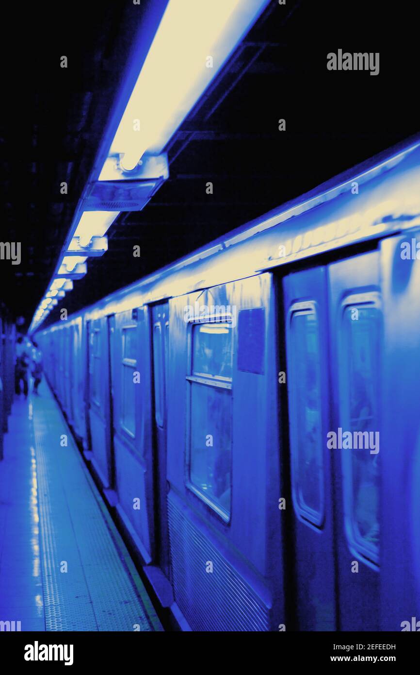 Train at a railroad station platform Stock Photo - Alamy