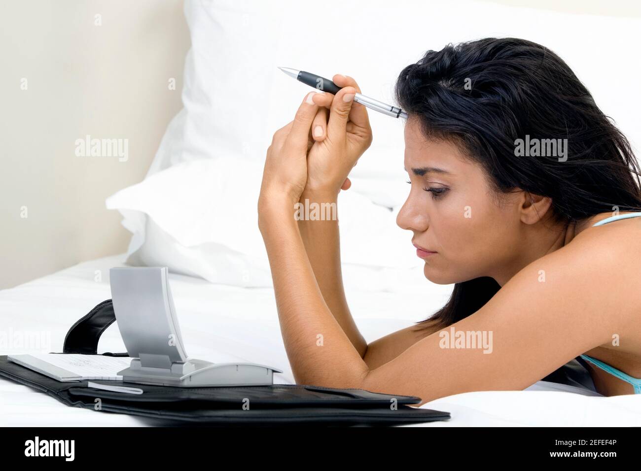 Side profile of a young woman lying on a bed in front of a personal ...