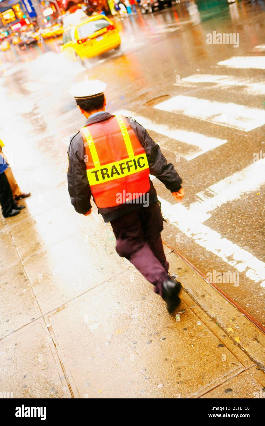 Rear view of a traffic cop walking on the road Stock Photo - Alamy