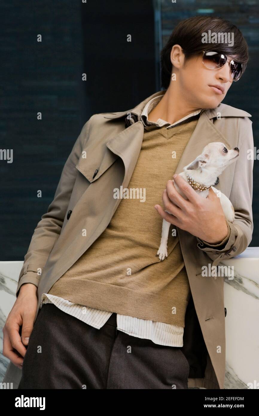 Young man carrying a puppy Stock Photo - Alamy