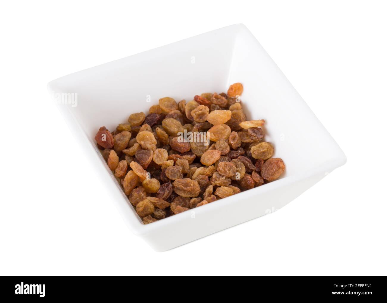 Dark raisins in a white square bowl. Isolated on a white background ...