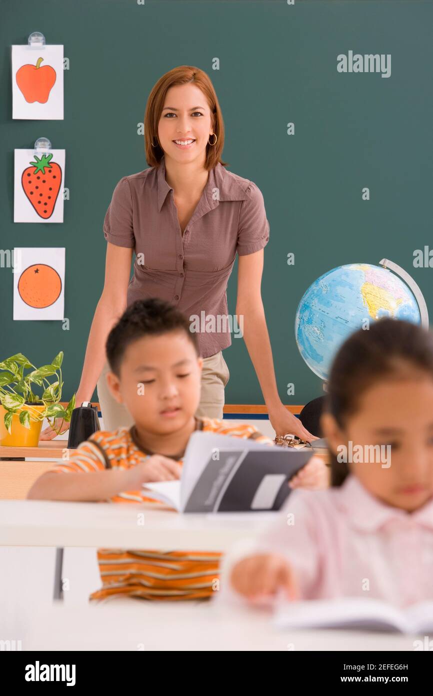 Female teacher teaching her students in a classroom Stock Photo - Alamy