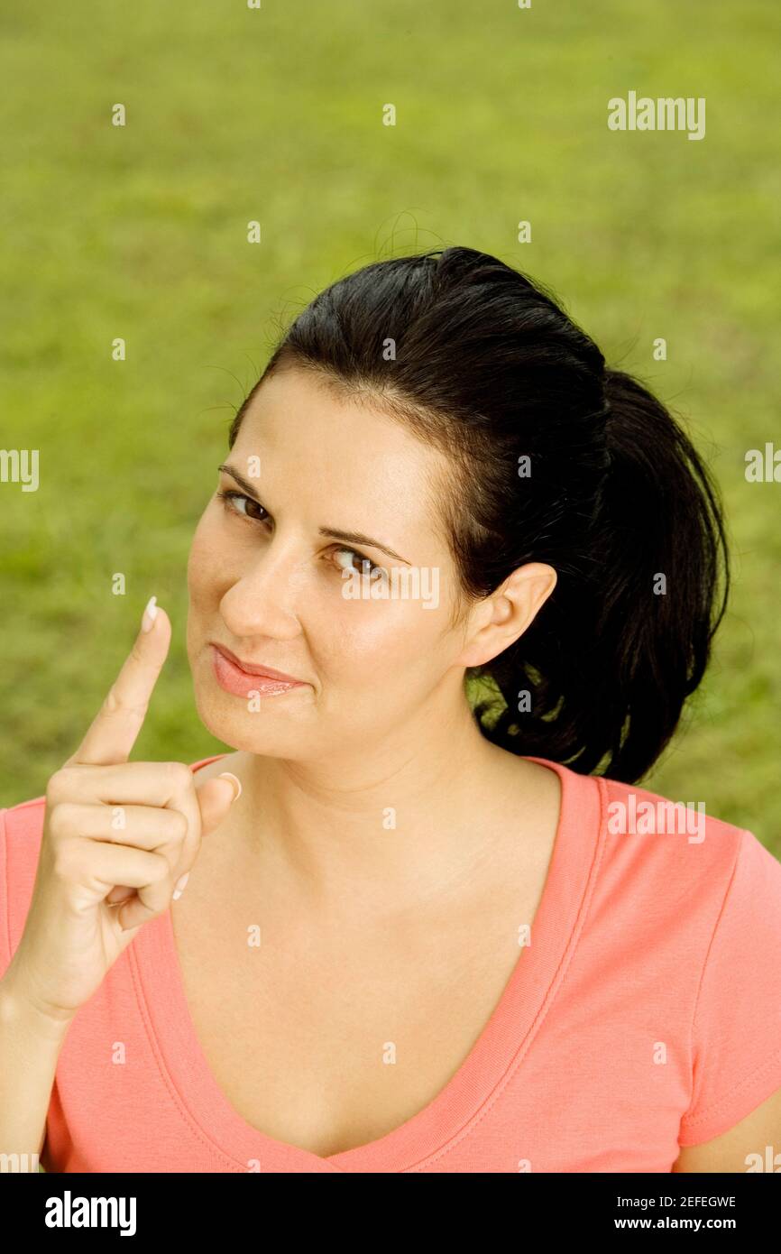 Portrait of a young woman pointing up Stock Photo - Alamy