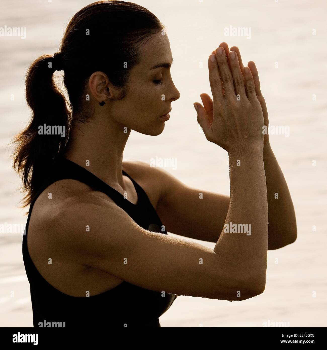 Side profile of a young woman meditating in a lake Stock Photo - Alamy
