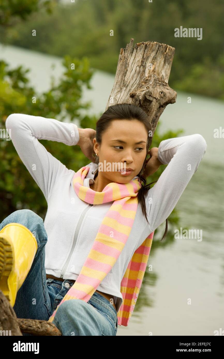 Young woman leaning against a tree stump Stock Photo - Alamy