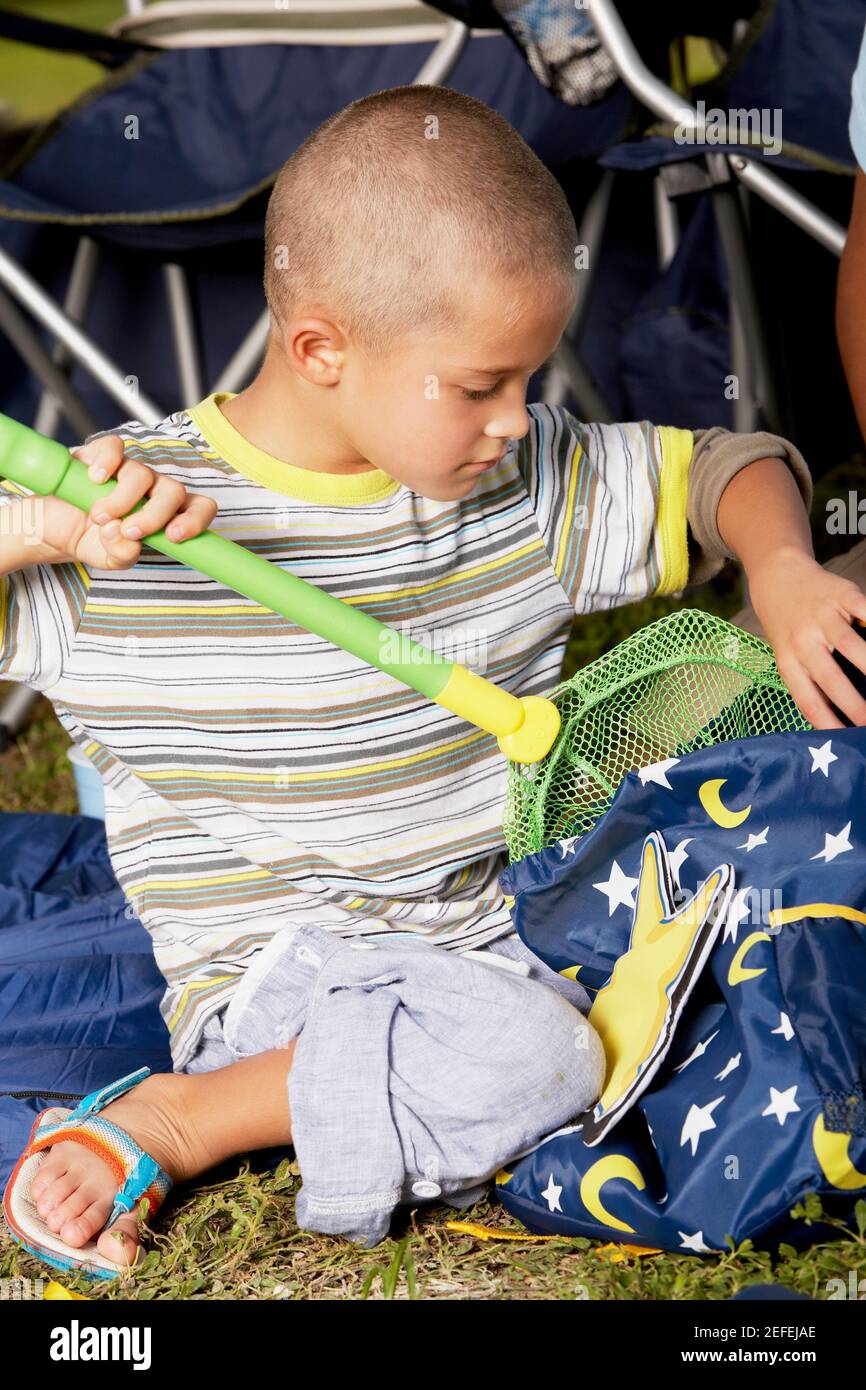 Boy putting a butterfly net into a bag Stock Photo - Alamy