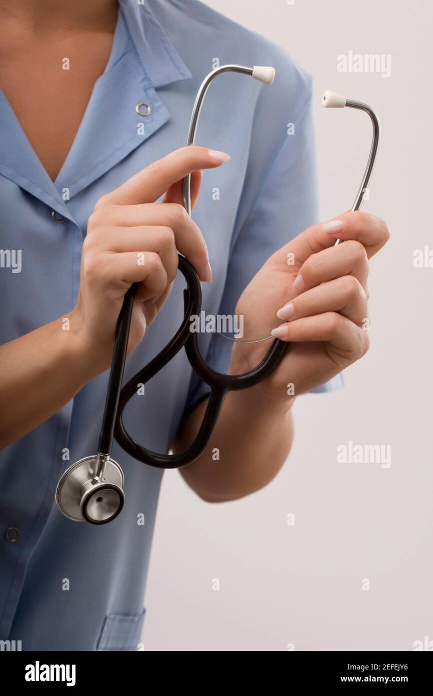 Female doctor holding a stethoscope Stock Photo - Alamy