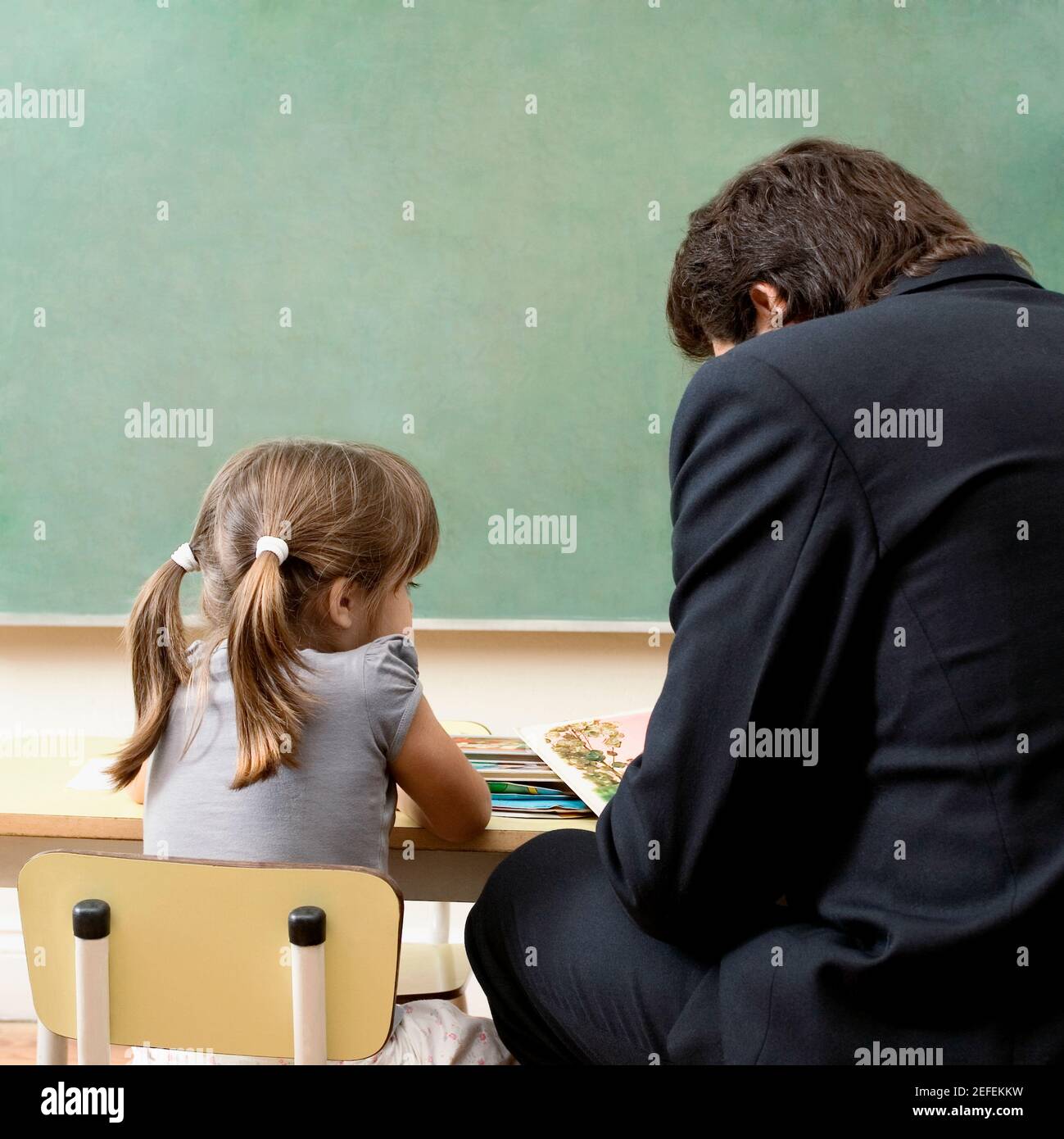 Male teacher teaching his student in a classroom Stock Photo - Alamy