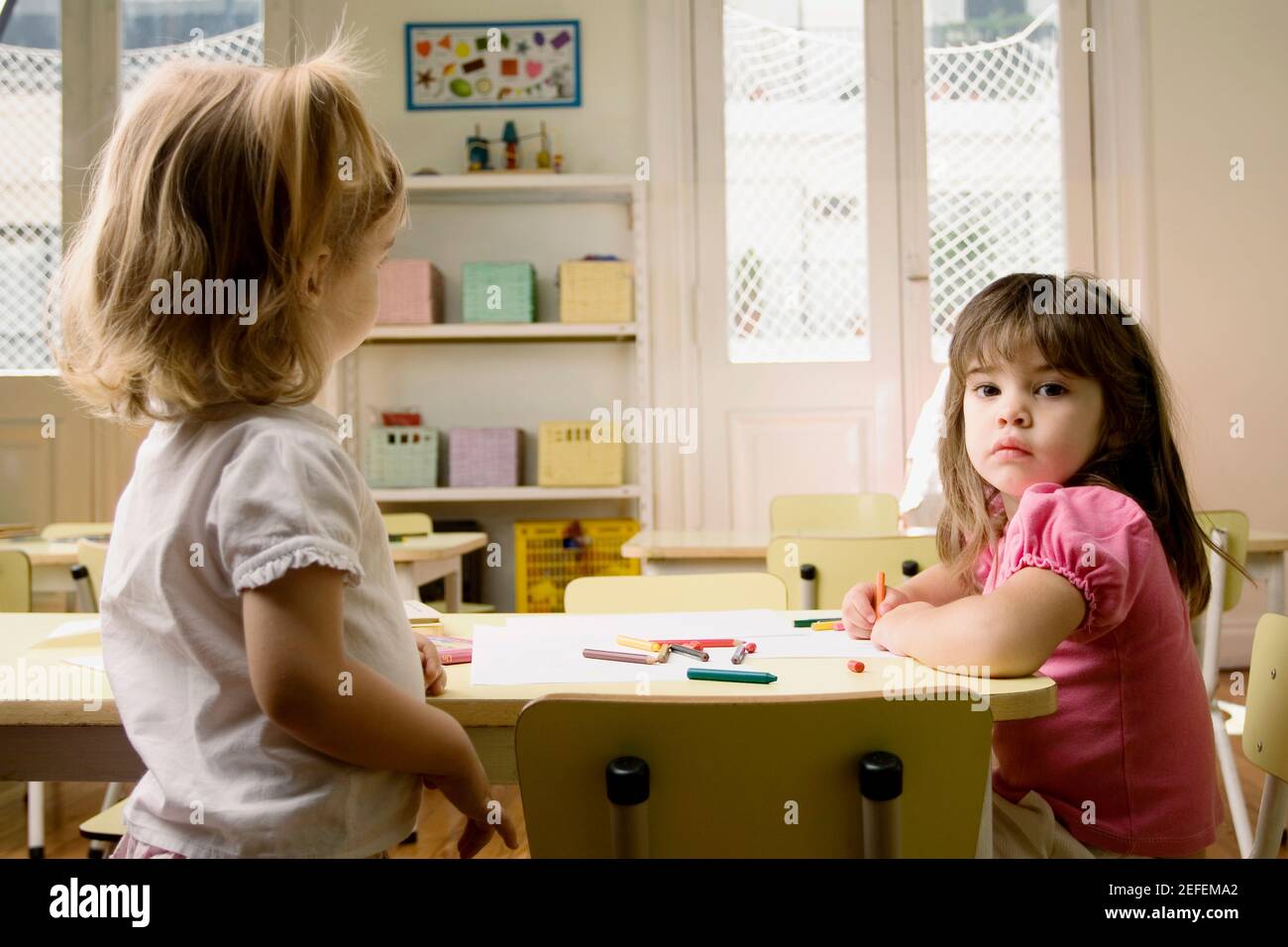 Side profile of two girls in a classroom Stock Photo - Alamy