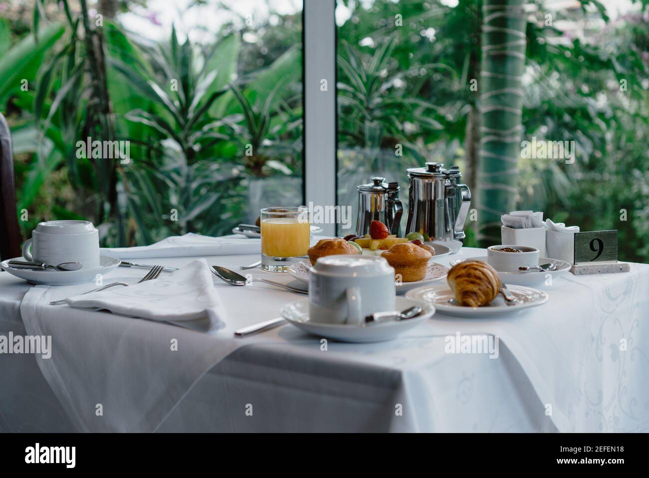 Served table for breakfast against the background of a large window ...