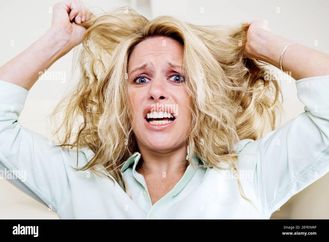 Portrait of a young woman pulling her hair Stock Photo - Alamy