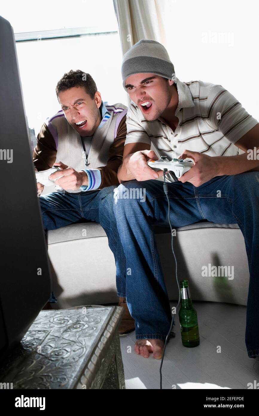 Young men playing a video game Stock Photo - Alamy