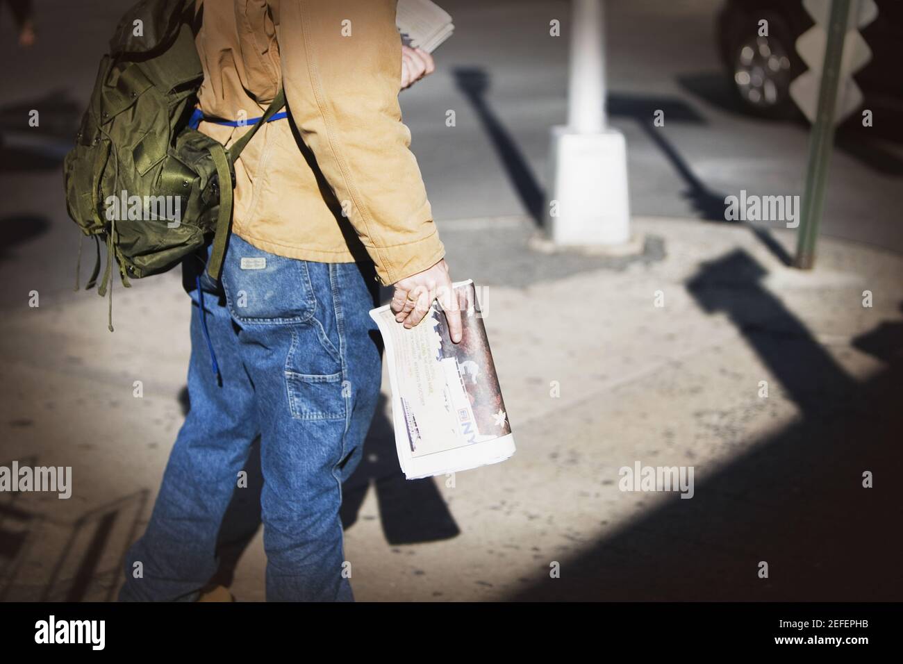 Low section view of a man selling newspapers Stock Photo - Alamy