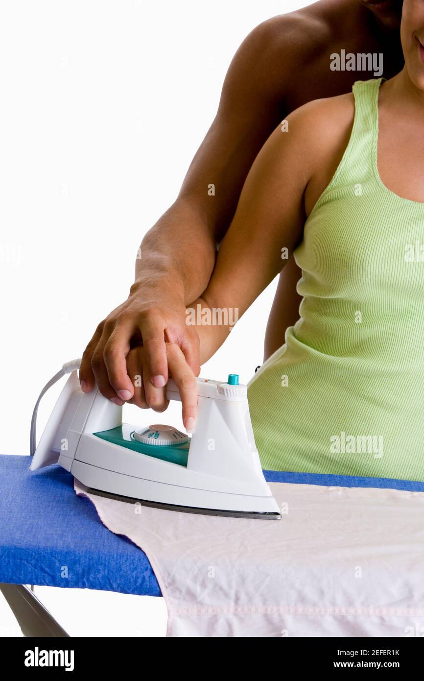 Mid section view of a couple ironing on an ironing board Stock Photo ...