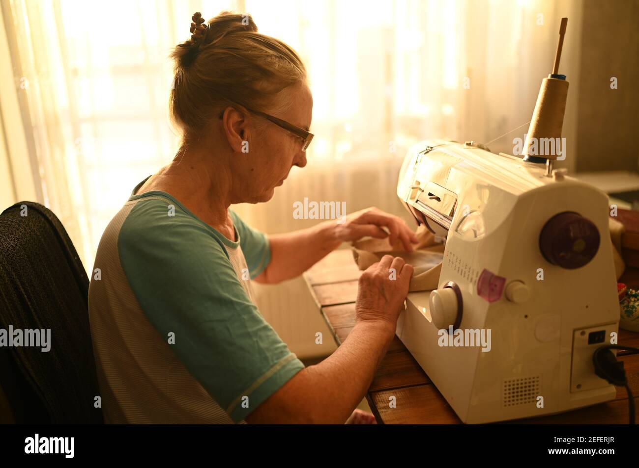 Confident senior elderly woman seamstress white shirt and glasses ...