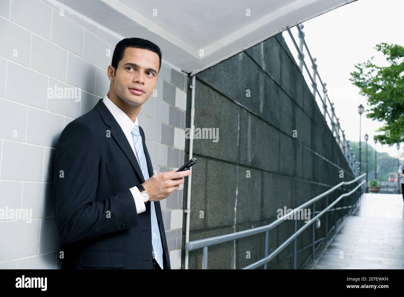 Side profile of a businessman holding a mobile phone in a subway Stock ...