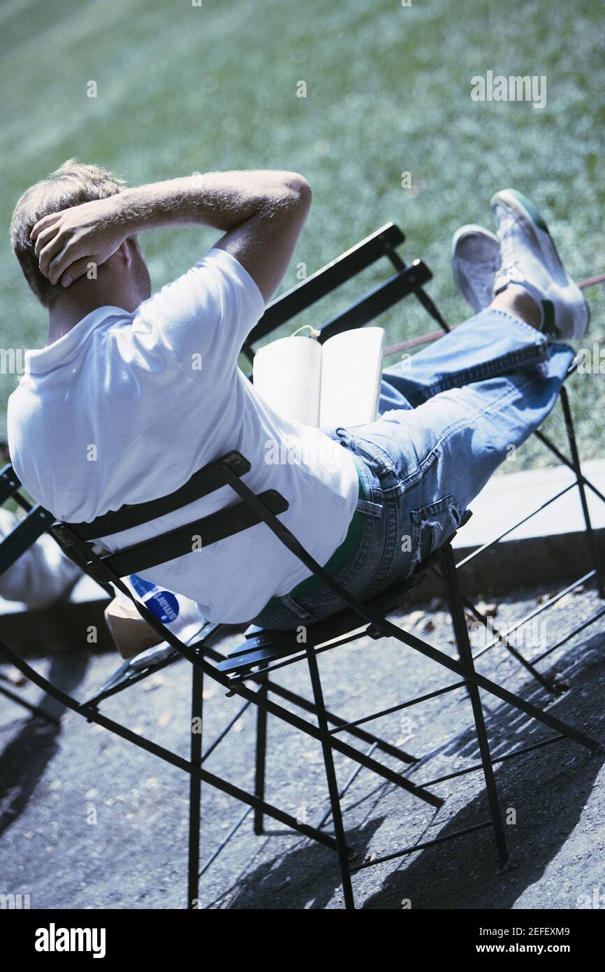 Rear view of a man reading a book Stock Photo - Alamy