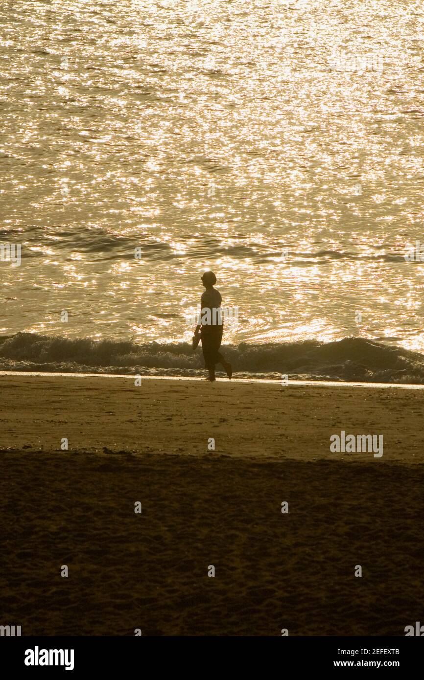 Side profile of a person walking on the beach, Grande Plage, Biarritz ...