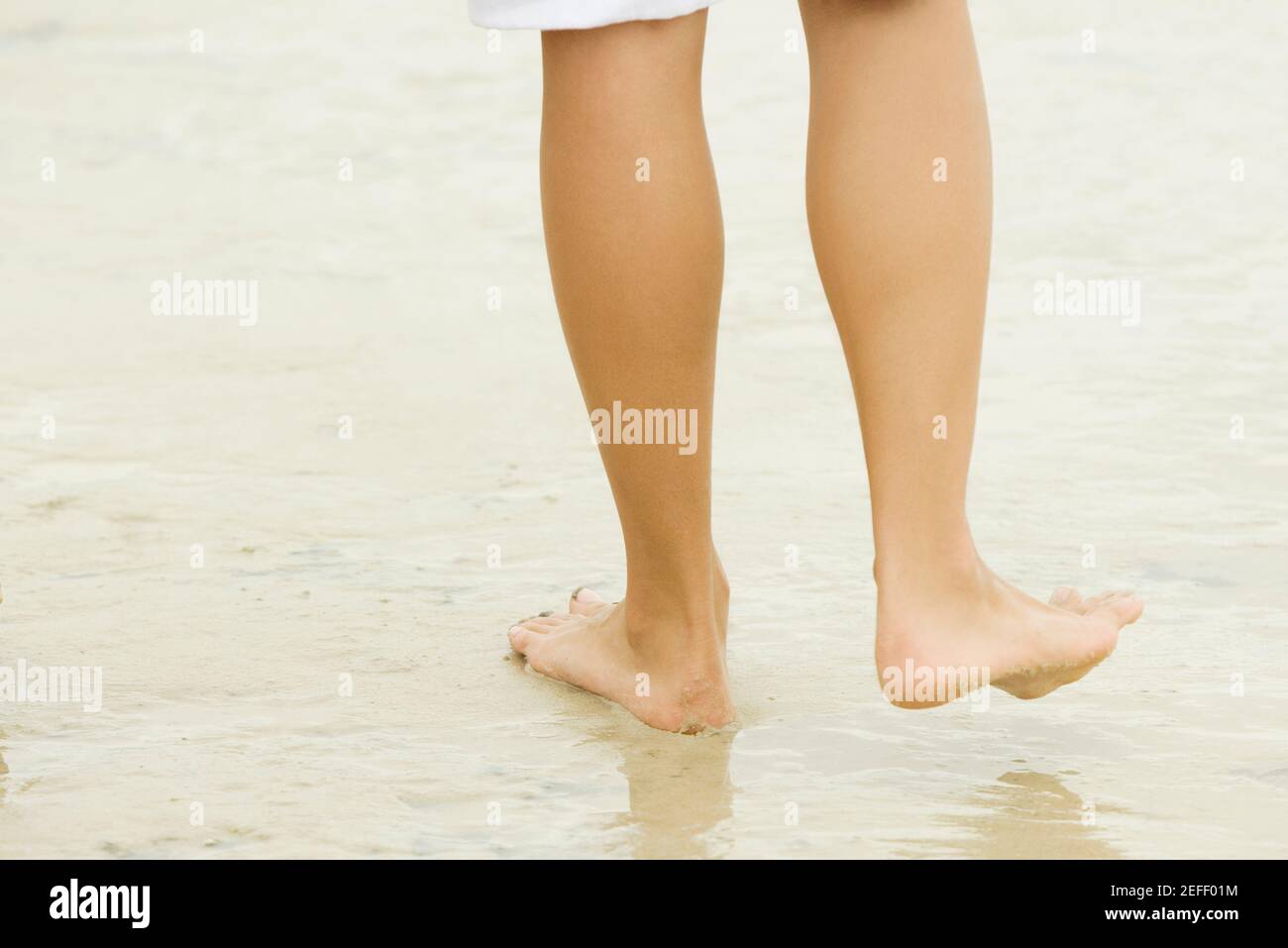 Low section view of a person walking on sand Stock Photo - Alamy