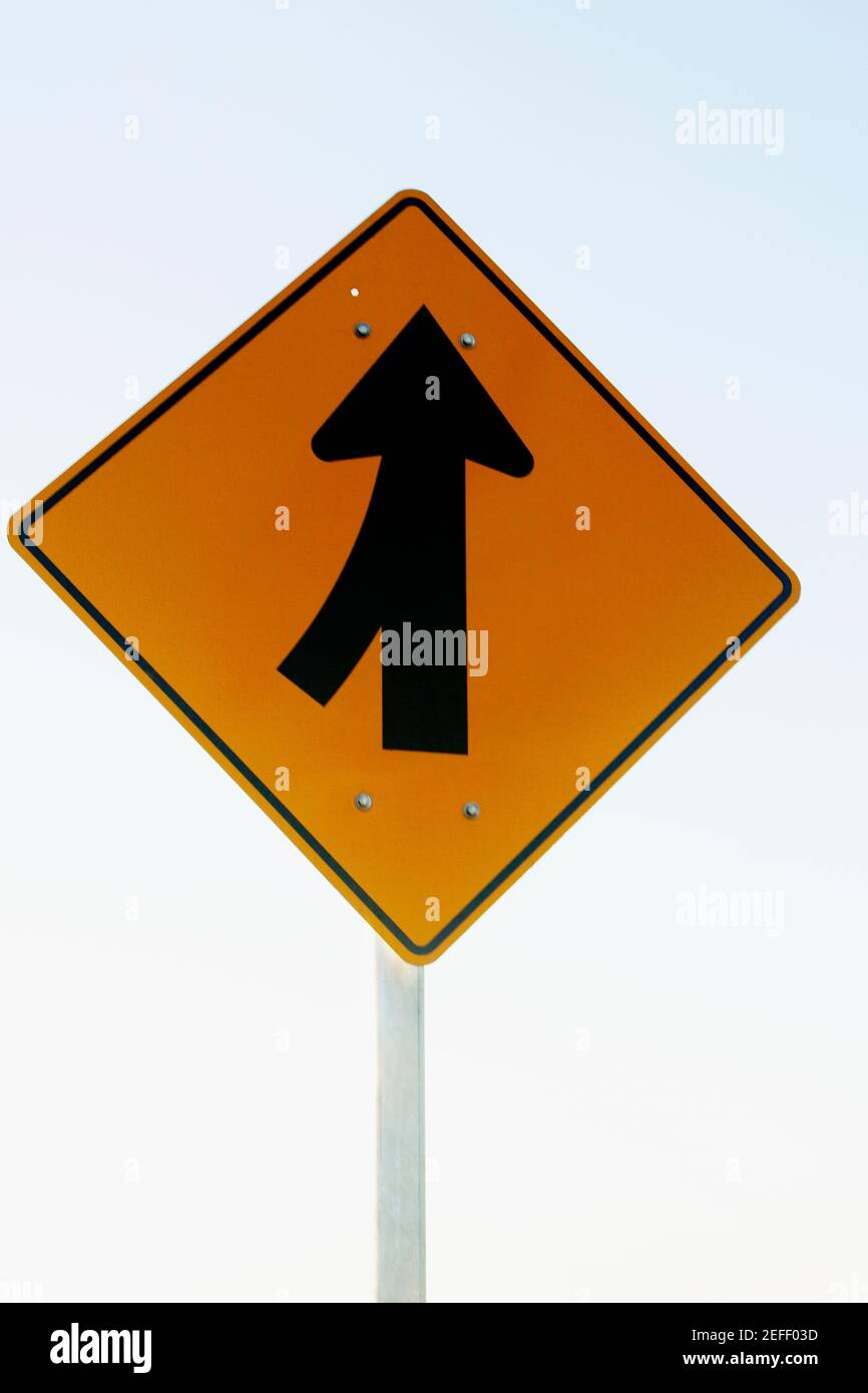 Low angle view of a merging sign Stock Photo - Alamy