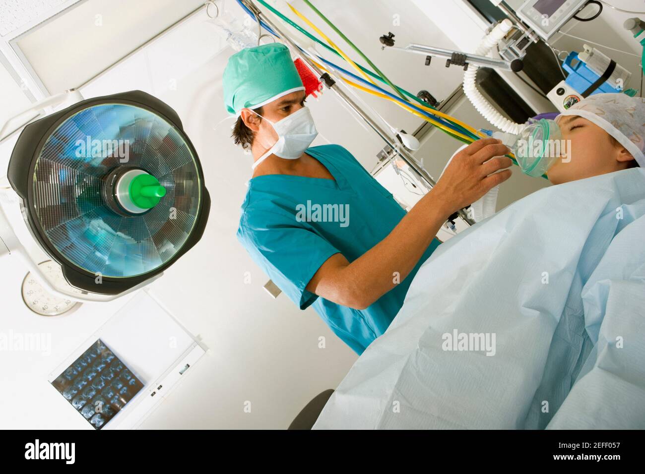Male surgeon putting an oxygen mask on the mouth of a female patient ...