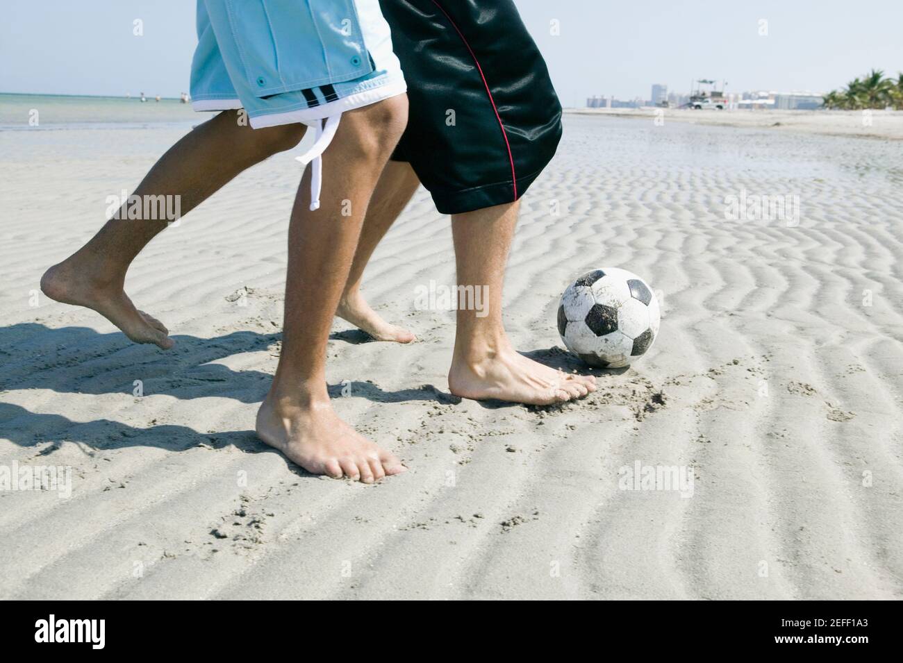 Low section view of two people playing with a soccer ball Stock Photo ...