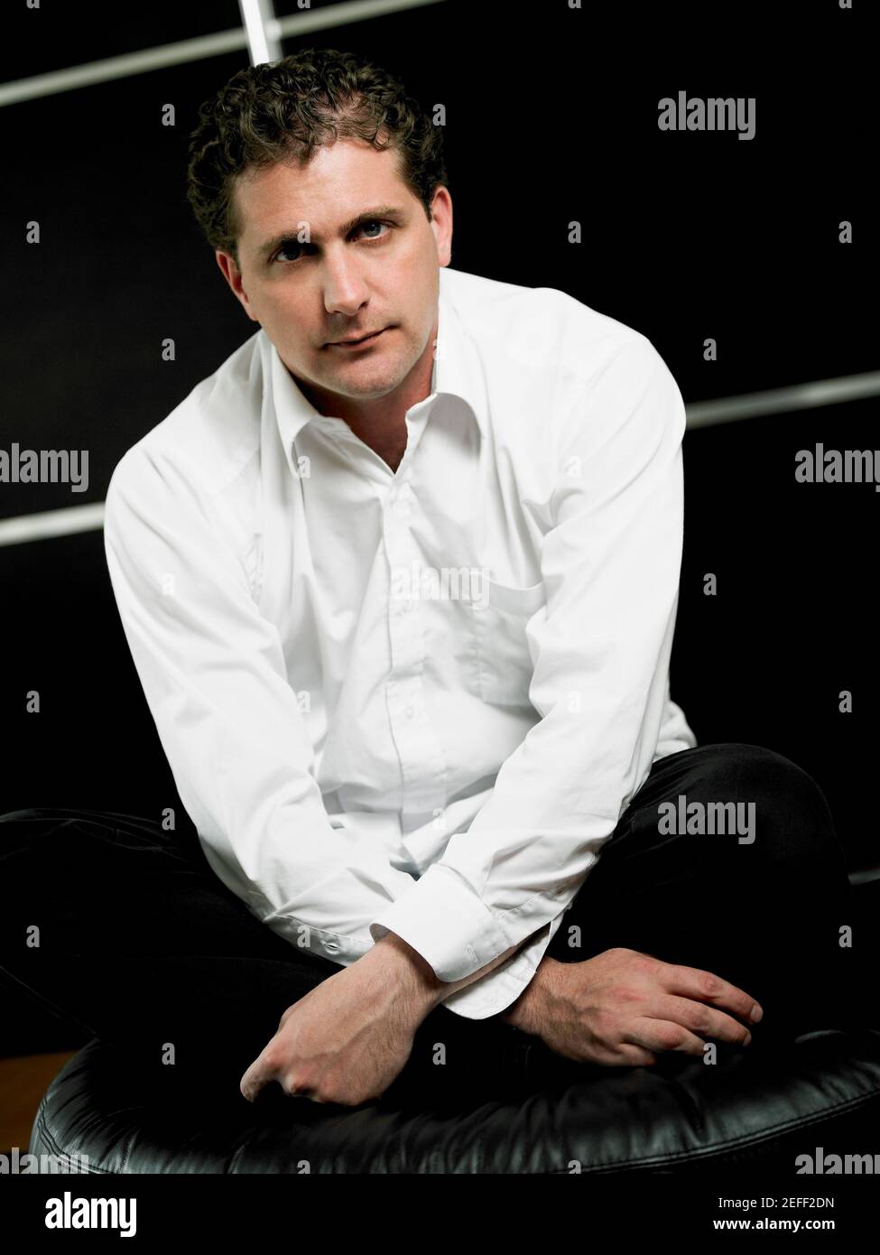 Portrait of a mid adult man with sitting with his legs crossed Stock ...