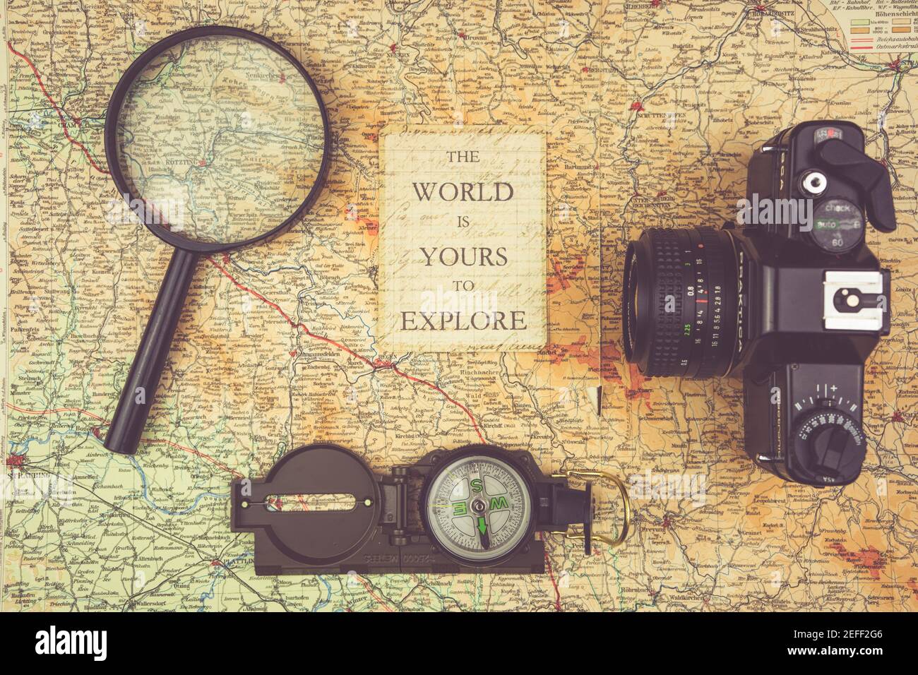 A top view of vintage magnifying glass, compass, and a photo camera on ...