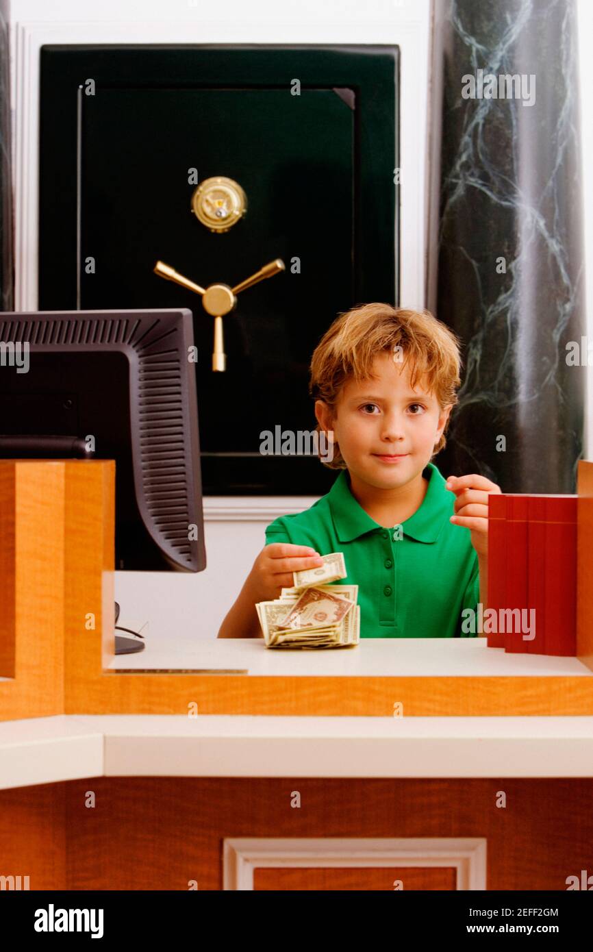 Boy imitating a cashier in a bank and counting currency notes Stock ...