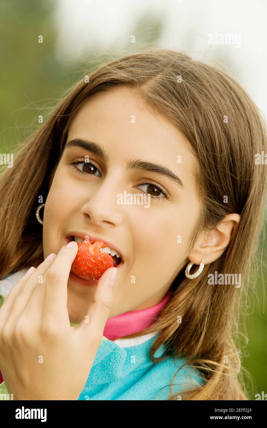 Portrait of a girl eating a strawberry Stock Photo - Alamy