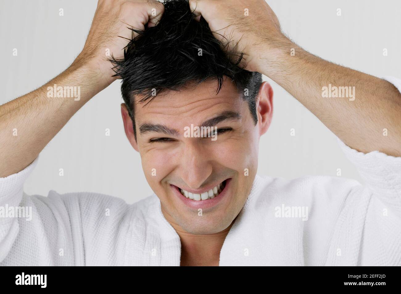 Portrait of a young man pulling his hair Stock Photo - Alamy