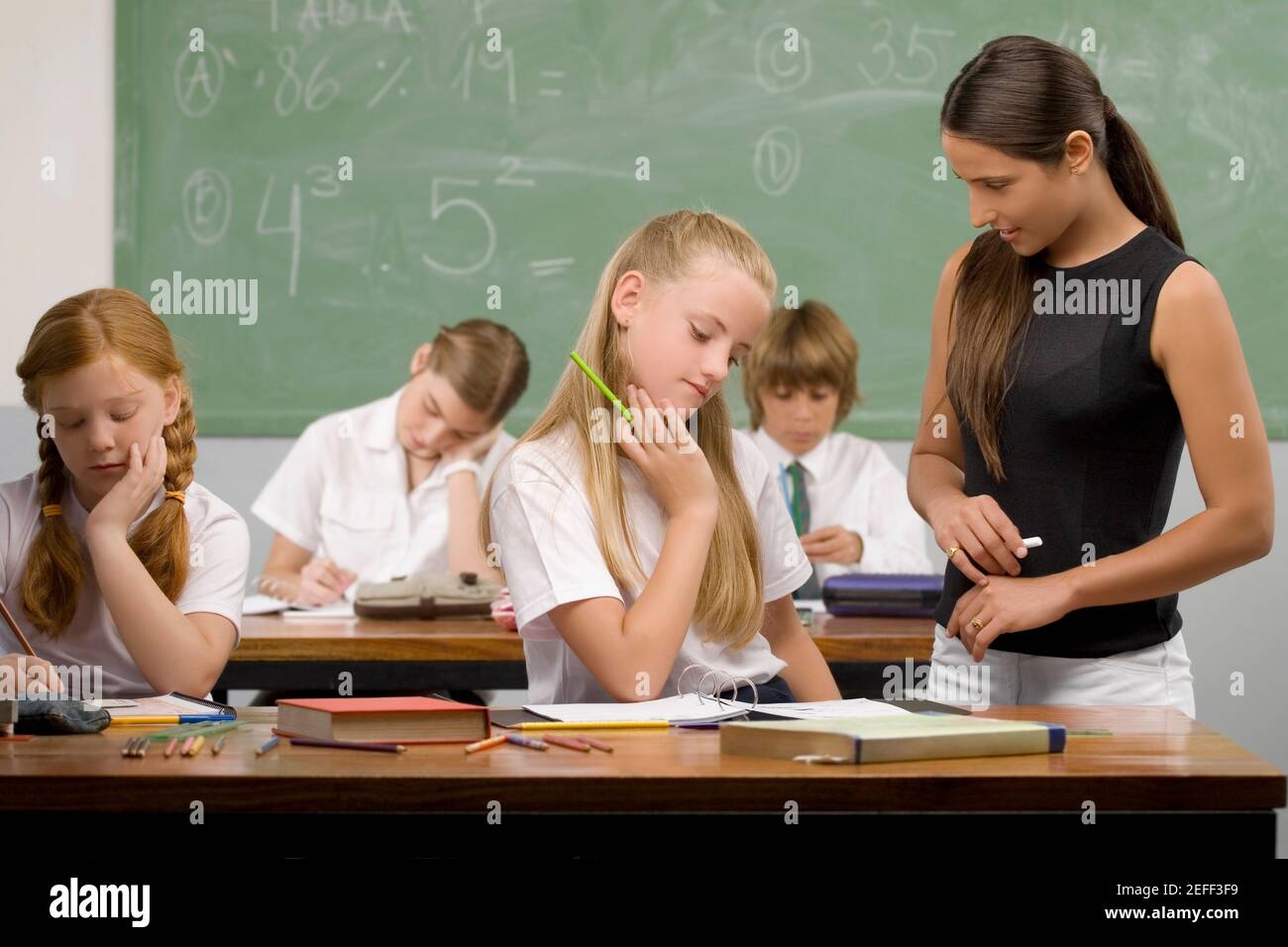 Female teacher teaching students in a classroom Stock Photo - Alamy