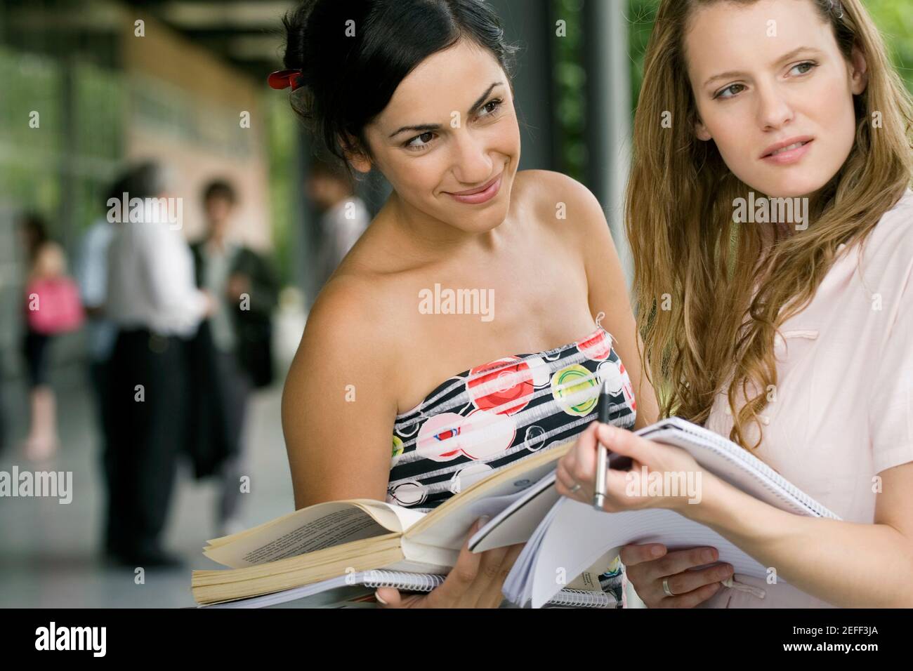 Two women standing holding book hi-res stock photography and images - Alamy