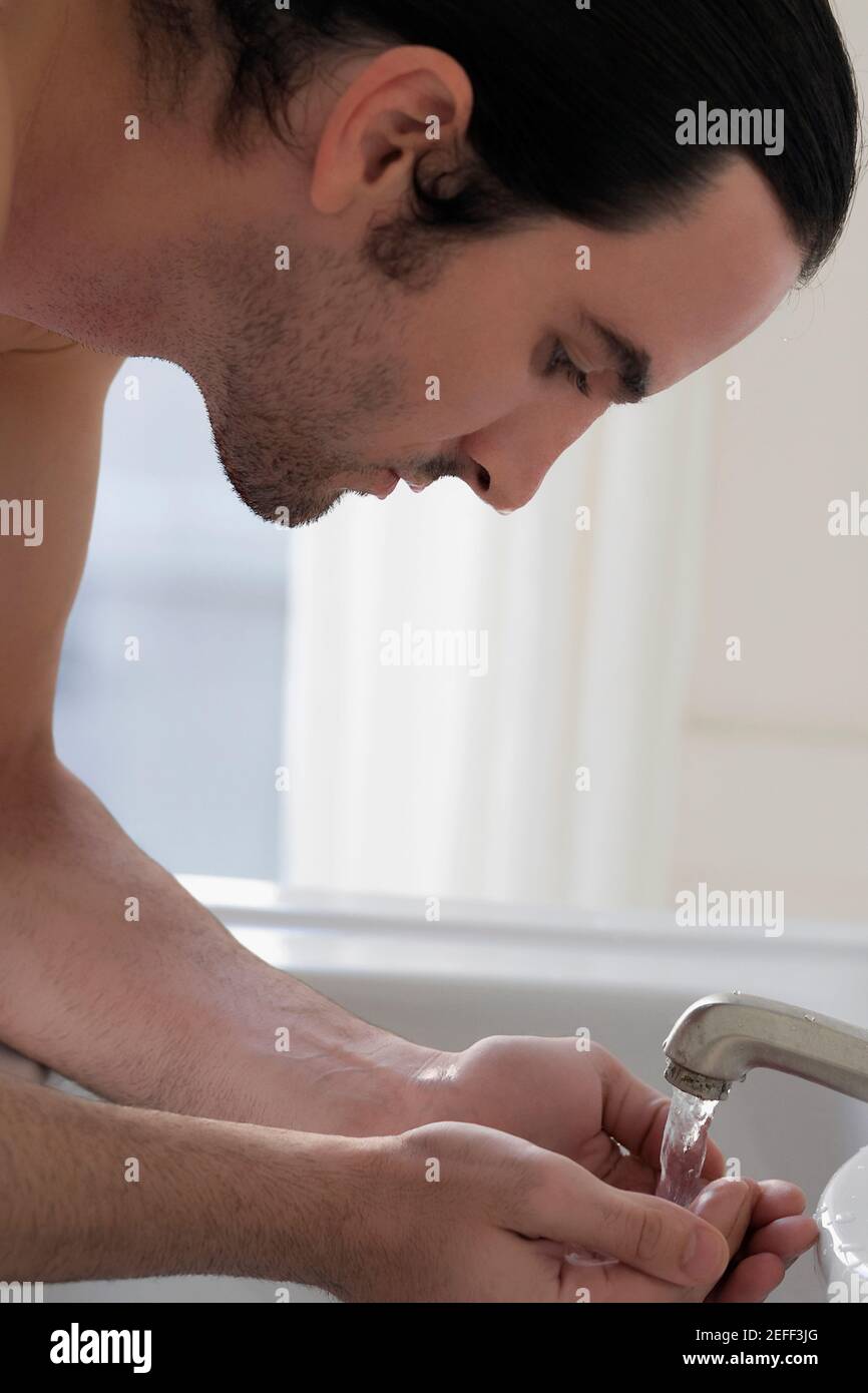 Close up of a young man washing his face Stock Photo - Alamy