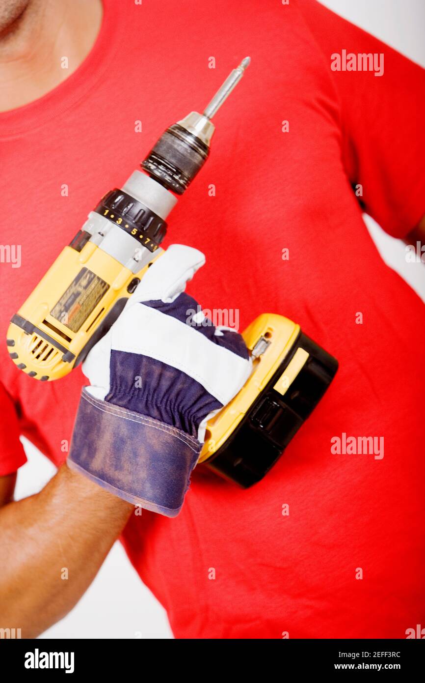 Mid section view of a man holding a drill machine Stock Photo - Alamy
