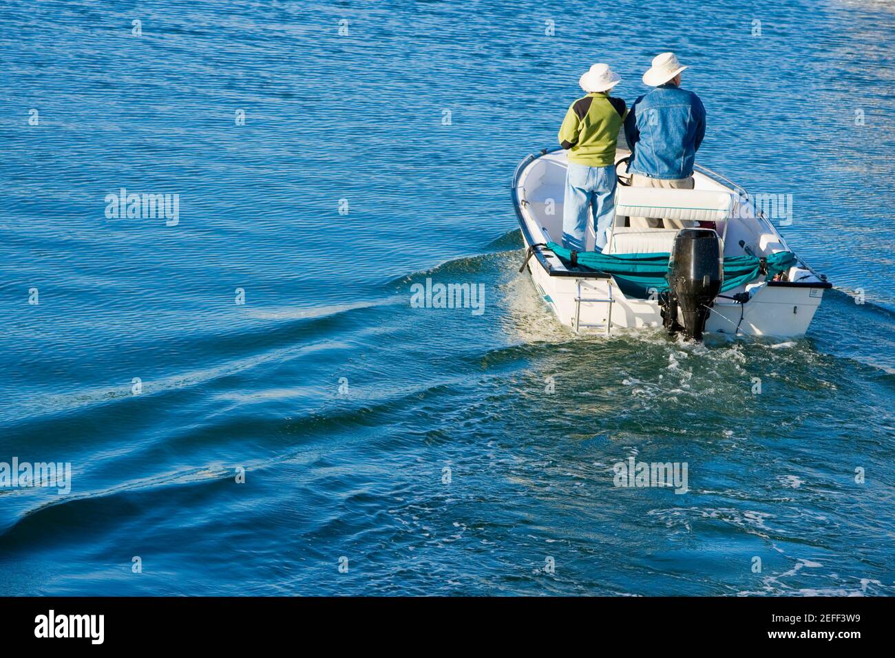 Rear view of two people in a motorboat Stock Photo - Alamy