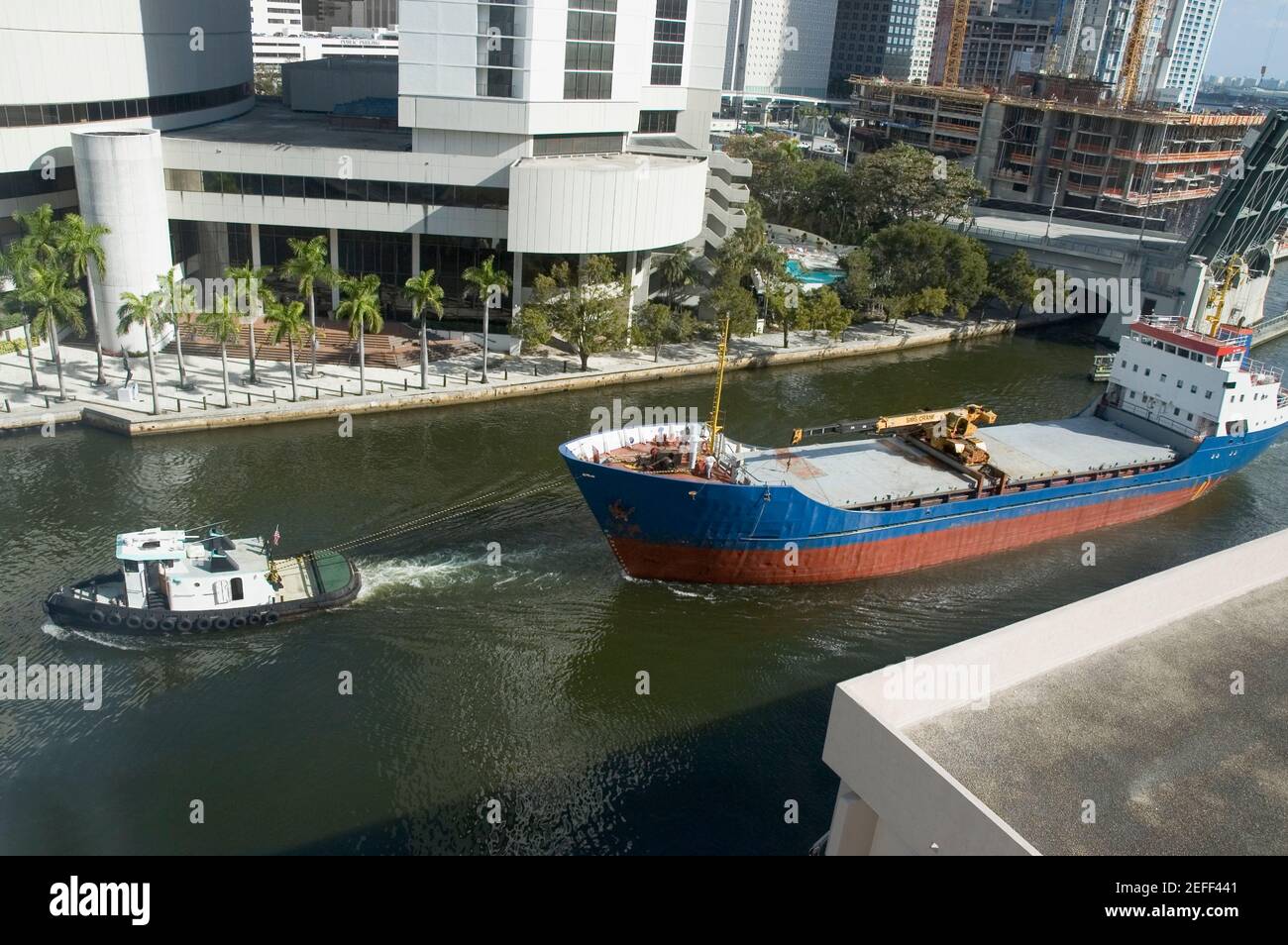 High angle view of a tugboat pulling a container ship Stock Photo - Alamy