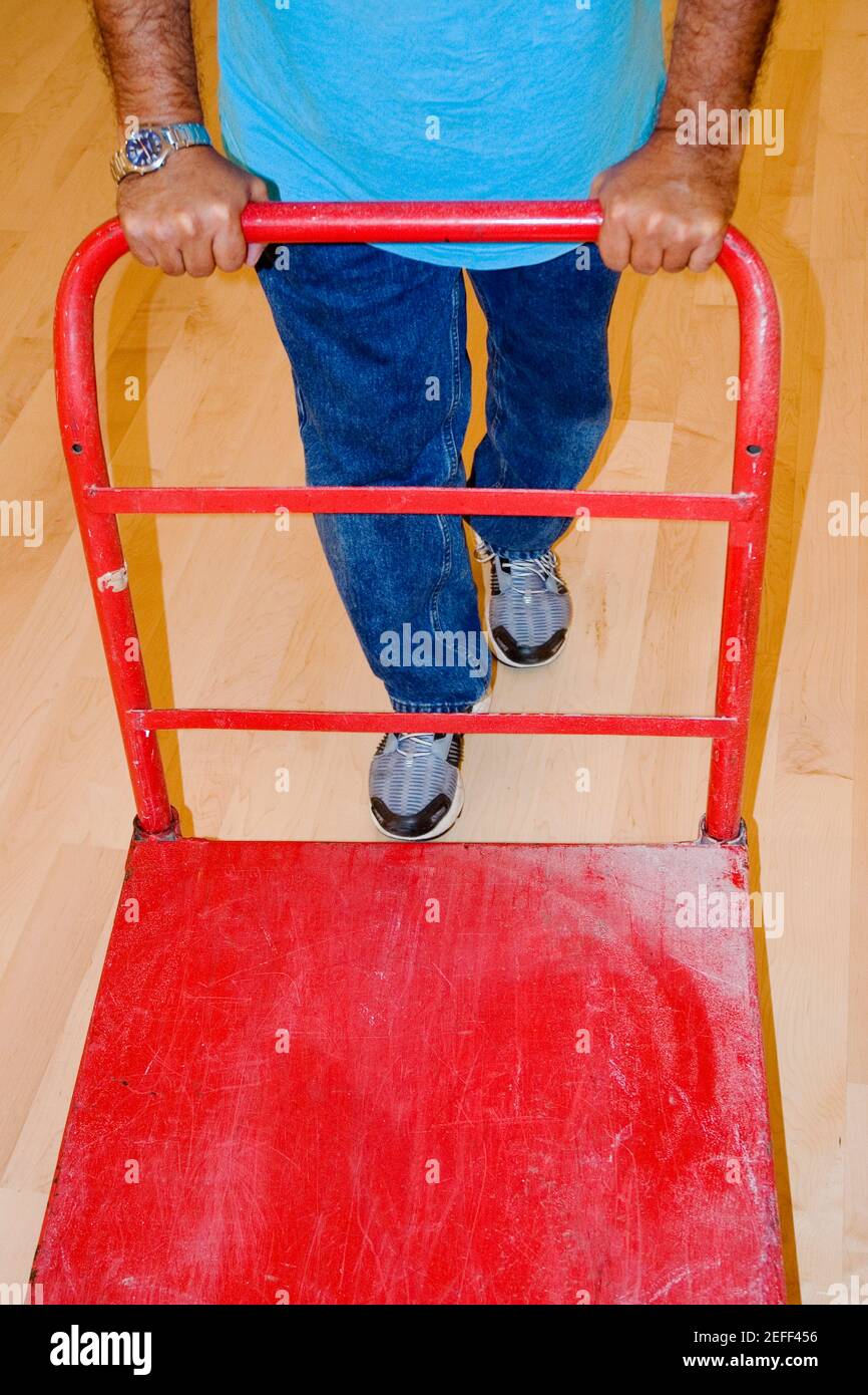 Low section view of a man pushing a trolley Stock Photo - Alamy
