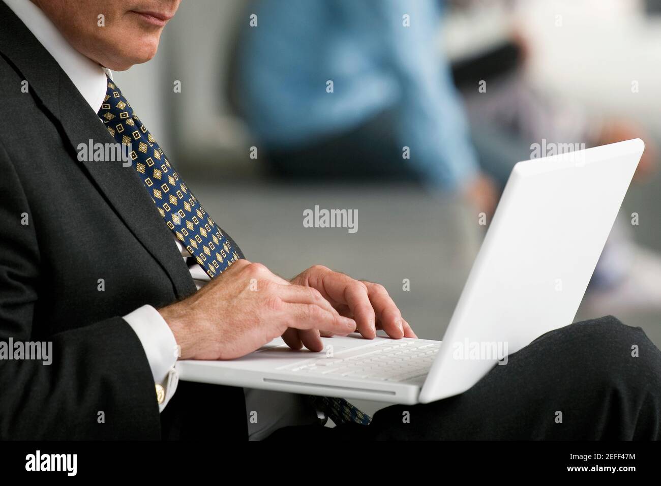 Close up of a professor using a laptop in a corridor Stock Photo - Alamy