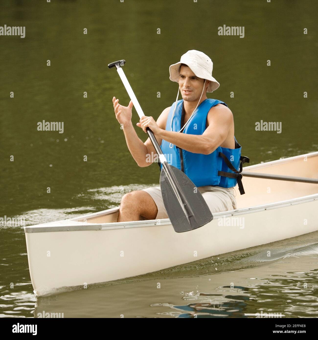Mid adult man boating in a lake Stock Photo - Alamy