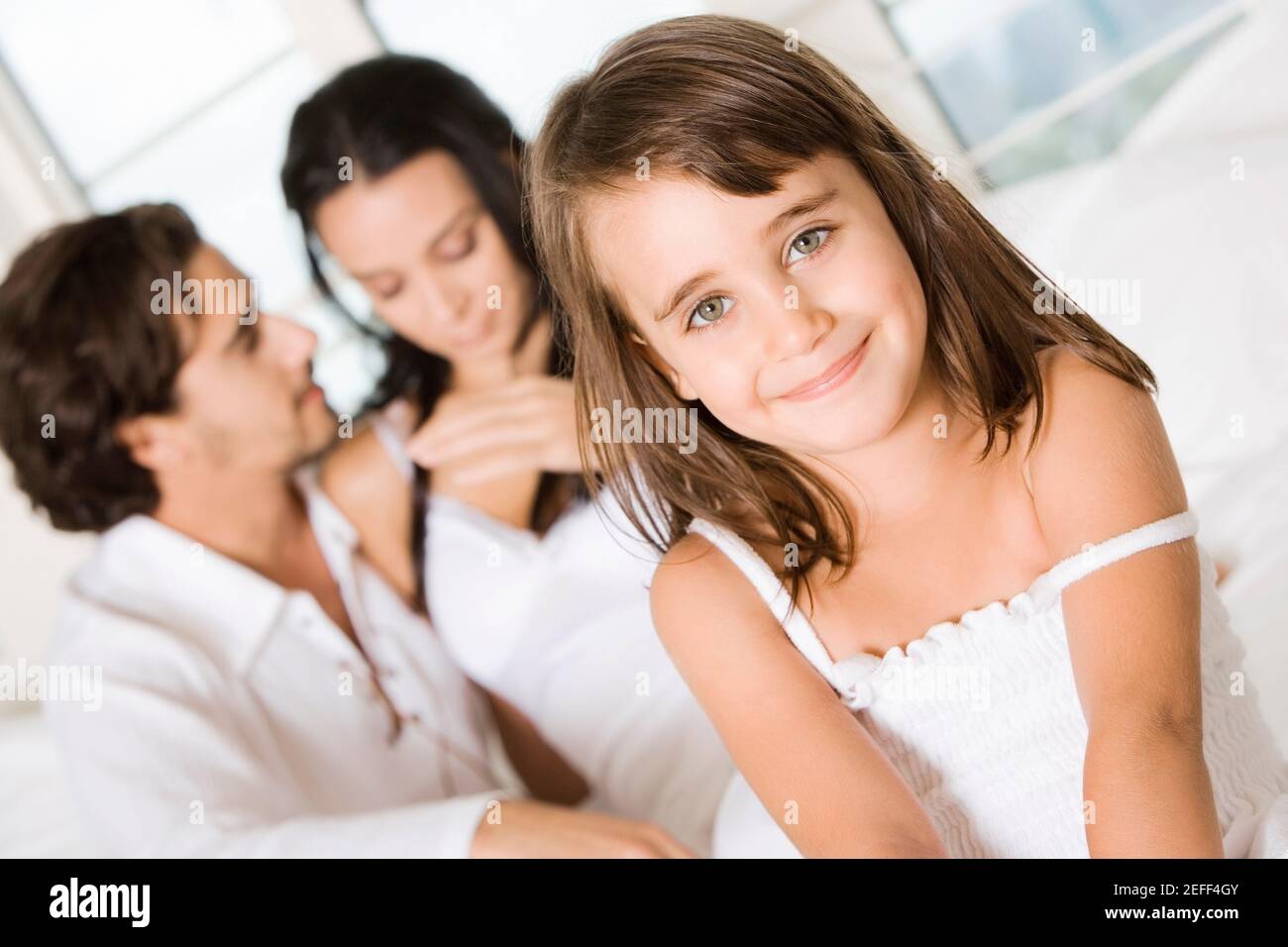 Portrait of a girl smiling with her parents behind her Stock Photo - Alamy