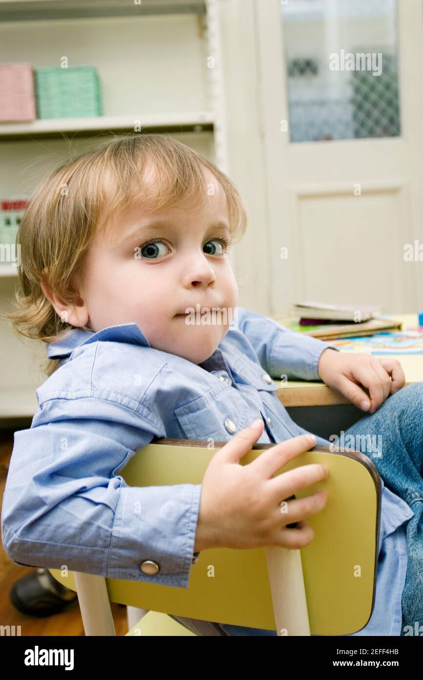 Portrait of a boy sitting on a chair Stock Photo - Alamy