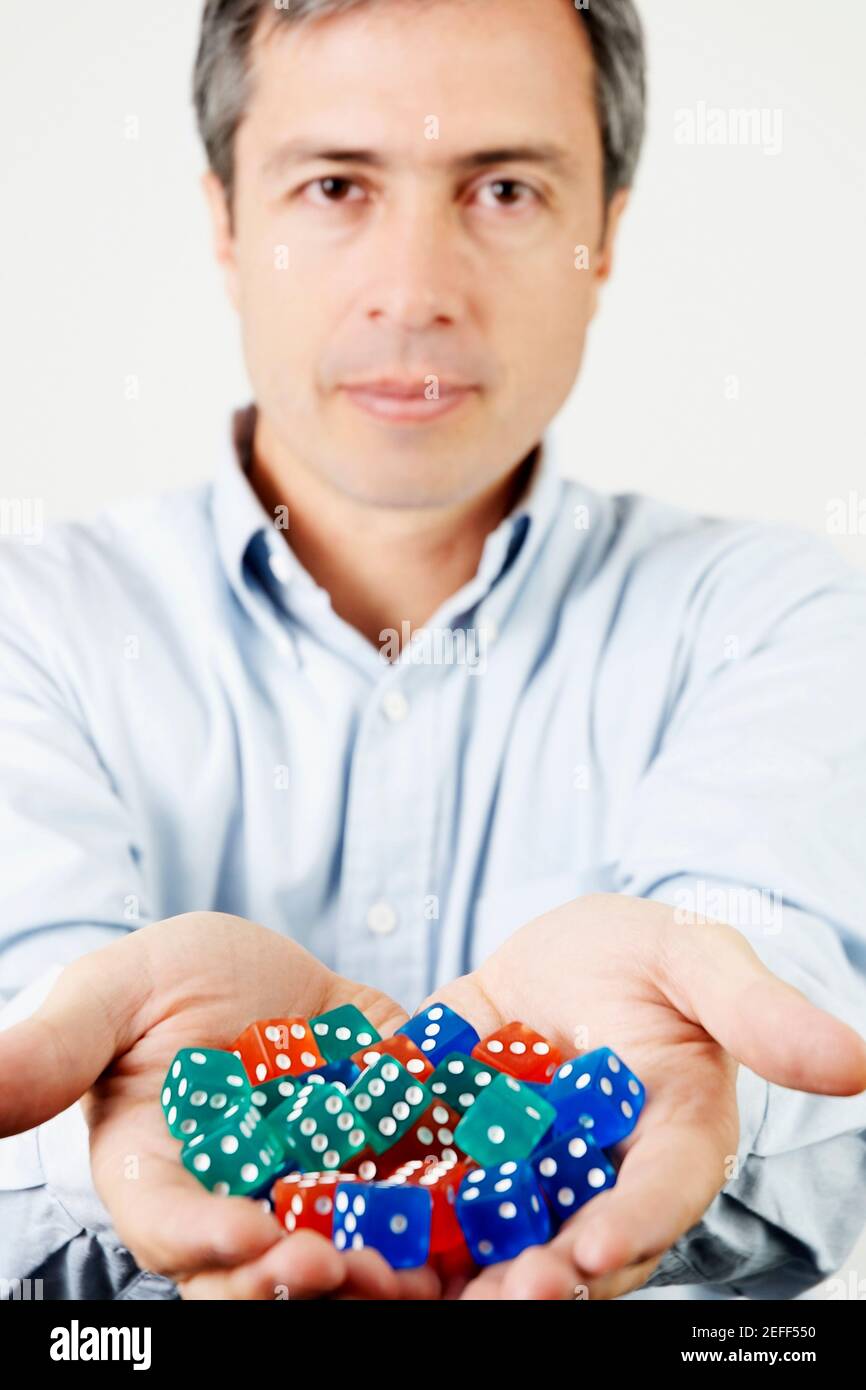 Portrait of a mature man showing dice in his cupped hands Stock Photo ...