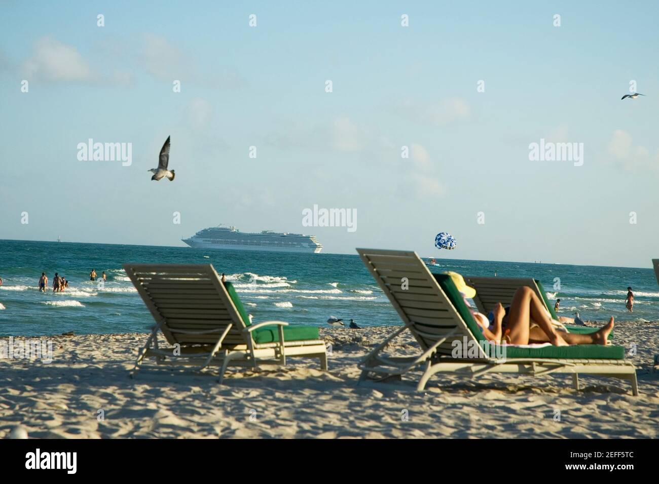 Side profile of a woman reclining on a lounge chair on the beach Stock ...